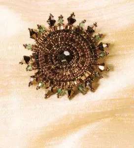 Pagkat-on unsaon paghimo og mga brooch nga adunay mga beads, sama niining brooch nga gitawag og Crystal Radiance nga makita sa among libre nga Beading Patterns for Seed Beads eBook.