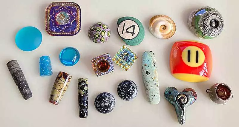 Unha variedade de opcións focais, que inclúen botóns de vidro checo, pedras preciosas, cabuchóns de lampwork, compoñentes de raku e cabuchóns de bola de billar.