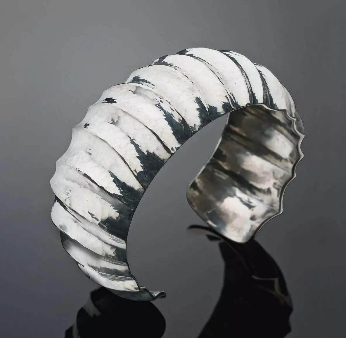 Bill Fretz te konte sou mato ak pikèt pou bay Argentium Fluted Cuff sa a fasinan teksti manyen li yo. Pwojè a te parèt orijinal nan Lapidary Journal Jewelry Artist Avril 2011 epi kounye a disponib tou nan konpilasyon 10 Pwojè fè bijou an ajan sansasyonalis ki sèvi ak Argentium® ki pa tache oswa tradisyonèl Sterling. Foto: Jim Lawson