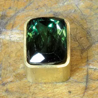 Ang paghimo og bezel para sa rectangular faceted nga bato nga adunay curved sides nagpresentar ug espesyal nga mga hagit. Green tourmaline sa partially built bezel ni Bill Fretz; litrato: Bill Fretz