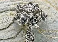 Il Wire Wrapped Metal Clay Bouquet è realizzato con la tecnica dei gioielli in metallo argilla del quilling e può essere trovato con le istruzioni passo passo nel nostro eBook gratuito Metal Clay Jewelry.